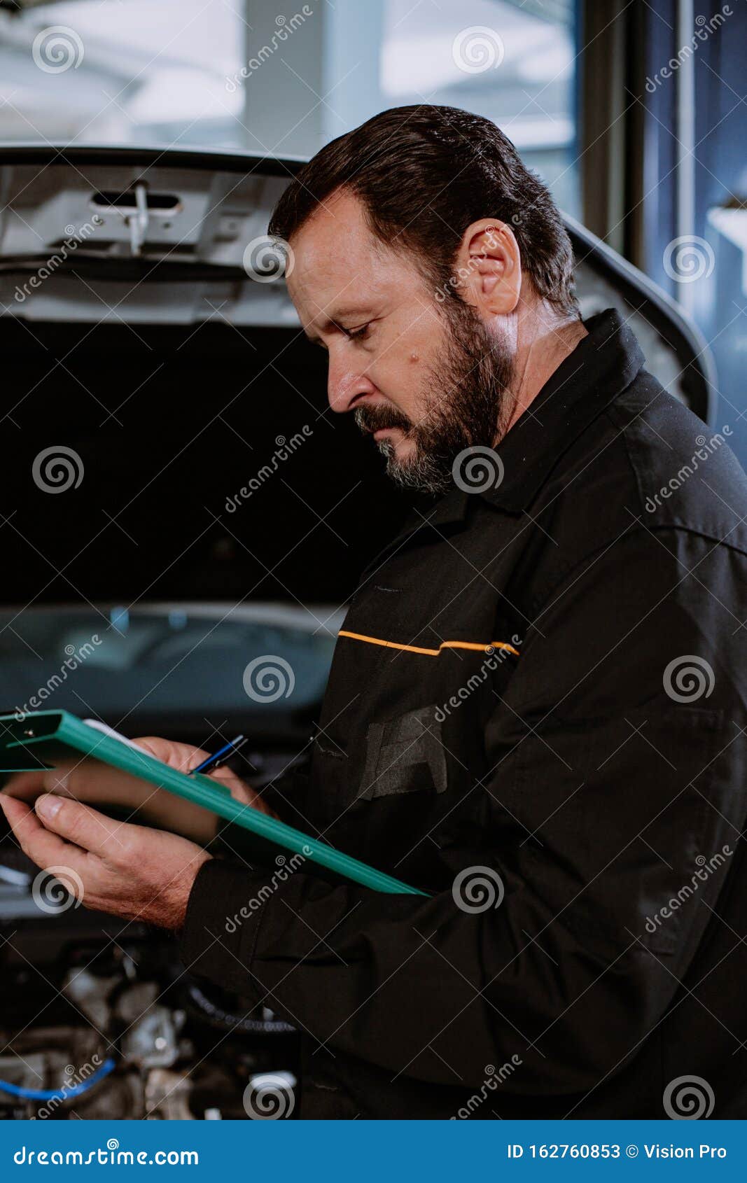 Mechanic Man in a Uniform Write the Problem of the Car in a Map in the ...