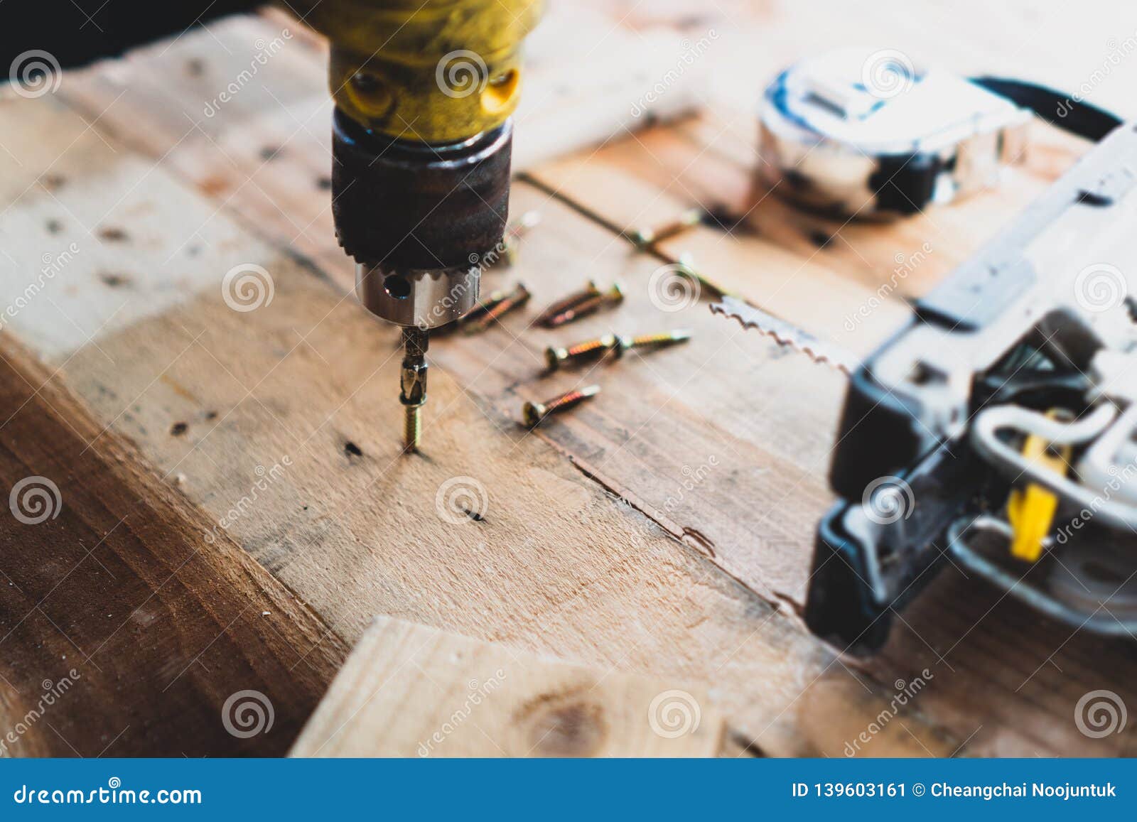 The Mechanic, the Man, is Using a Drill To Drill Wood in the ...