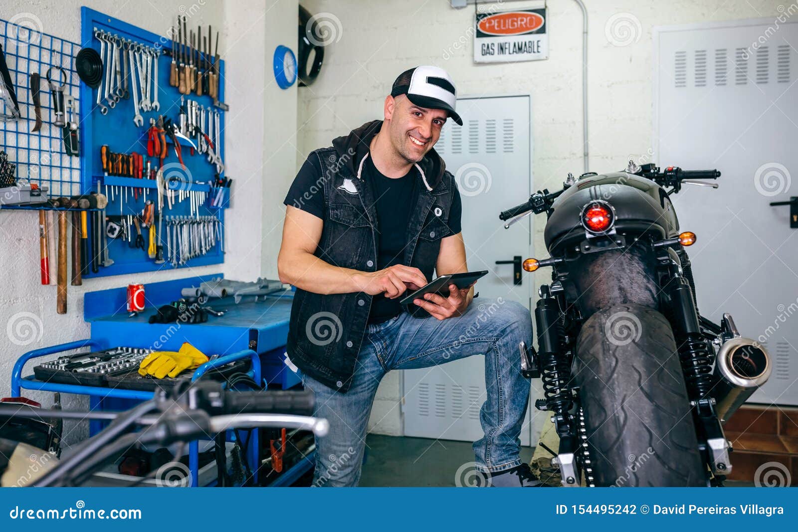 Mechanic Checking Custom Motorcycle with Tablet Stock Photo - Image of ...