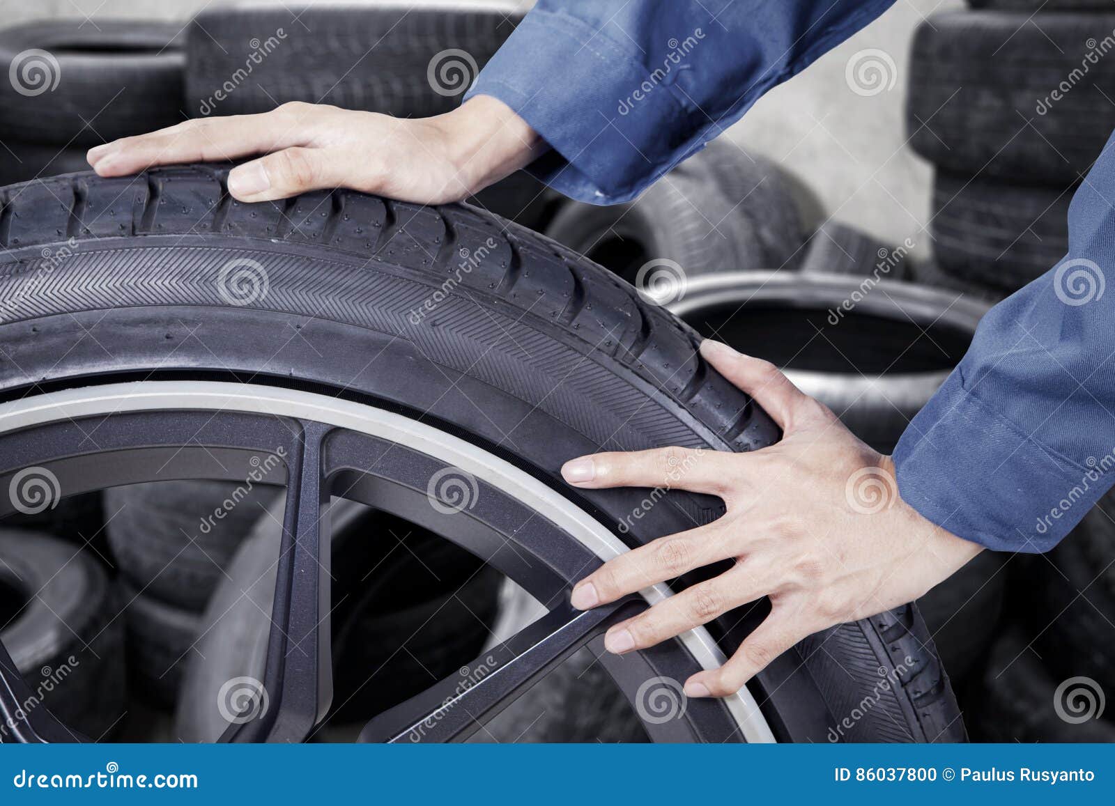 Mechanic Pushing Black Tyre Stock Photo - Image of push, hold: 86037800