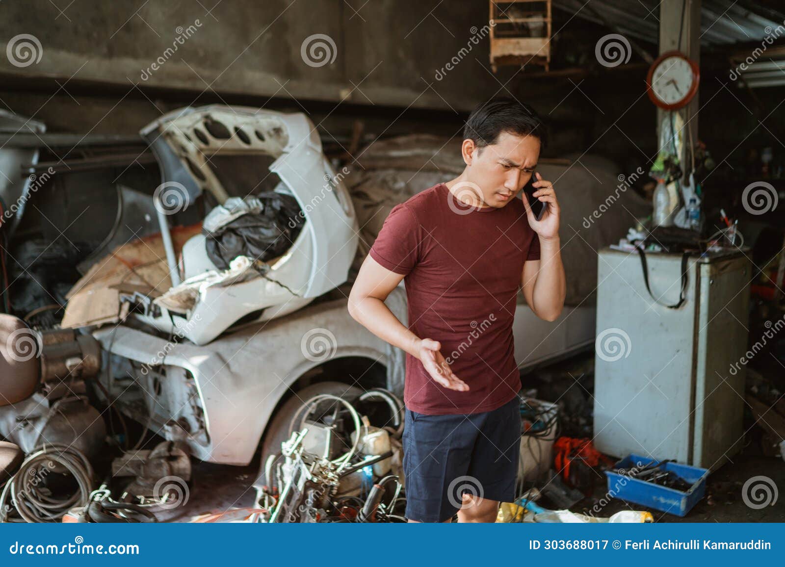 Mechanic Taking a Cell Phone Call Standing in an Old Garage Stock Image ...