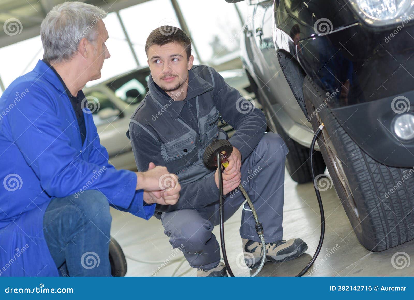 Mechanic and Trainee Working on Car Together Stock Photo - Image of ...