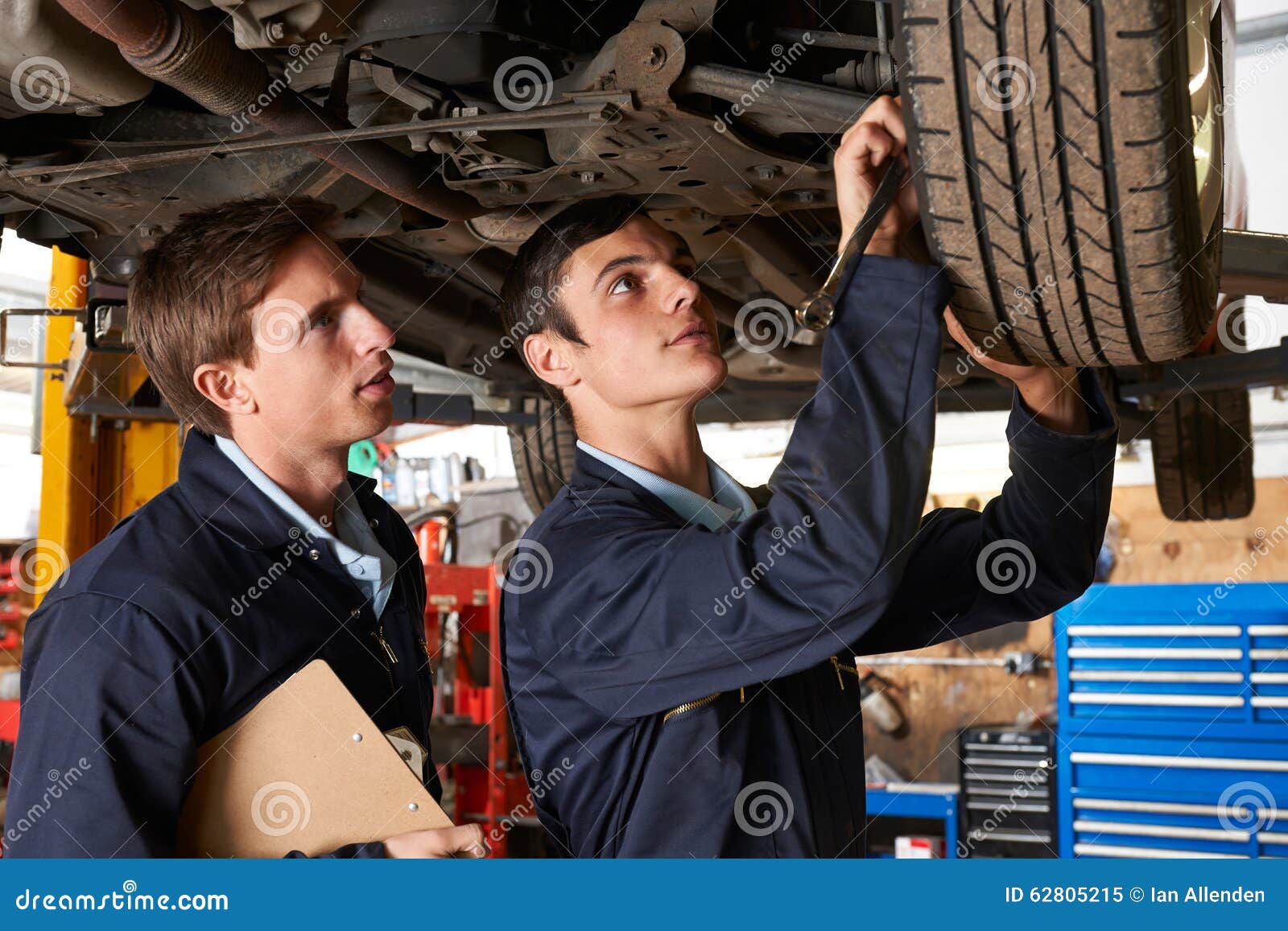 Mechanic and Trainee Working on Car Together Stock Image - Image of ...