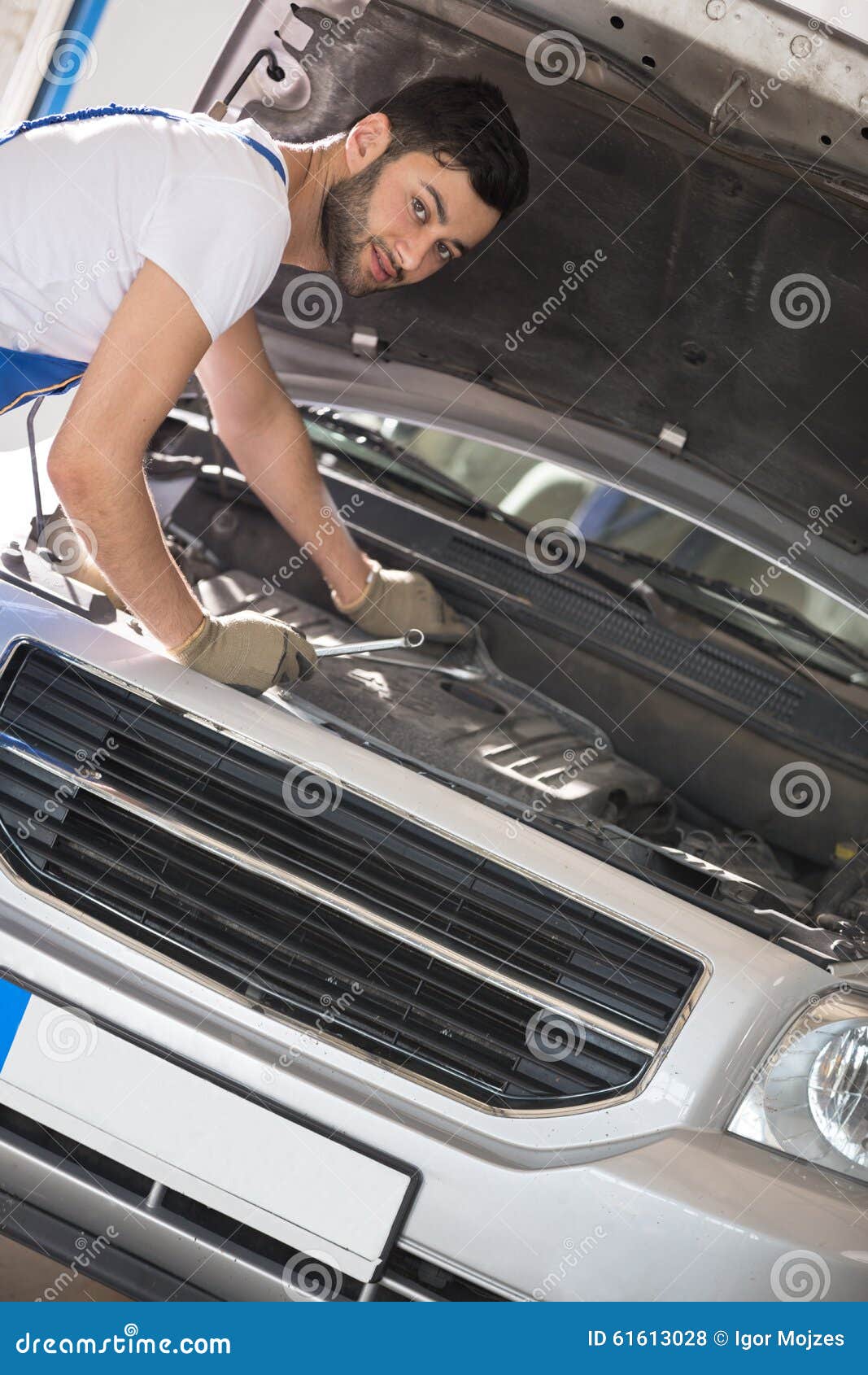 Mechanic under the hood stock photo. Image of automotive - 61613028