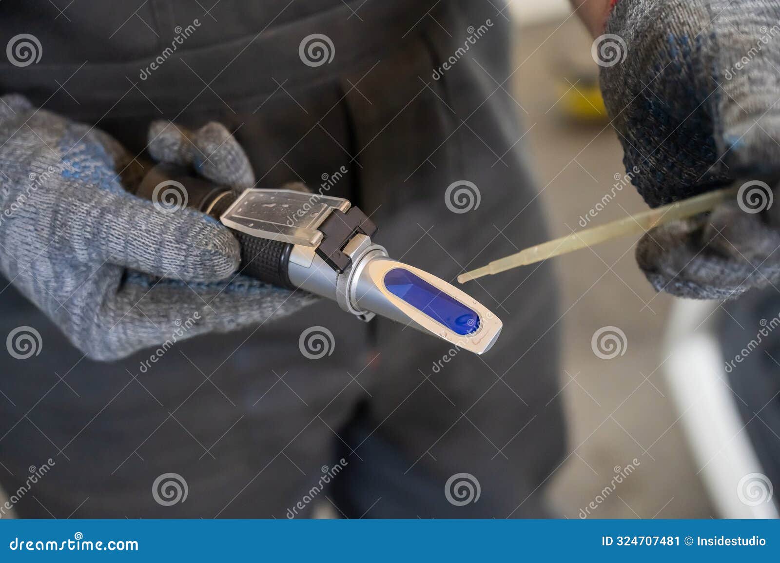 A Mechanic Uses a Refractometer in a Car Service. Portable Optical ...