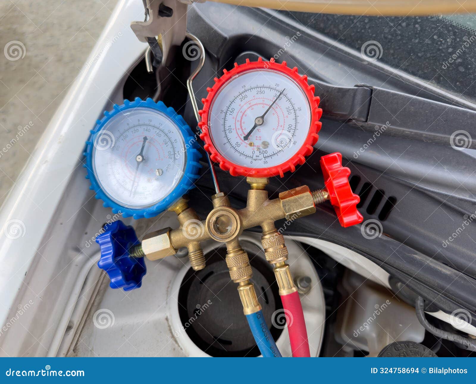 Mechanic Using a C Manifold Gauge Set To Check Air Condition System ...