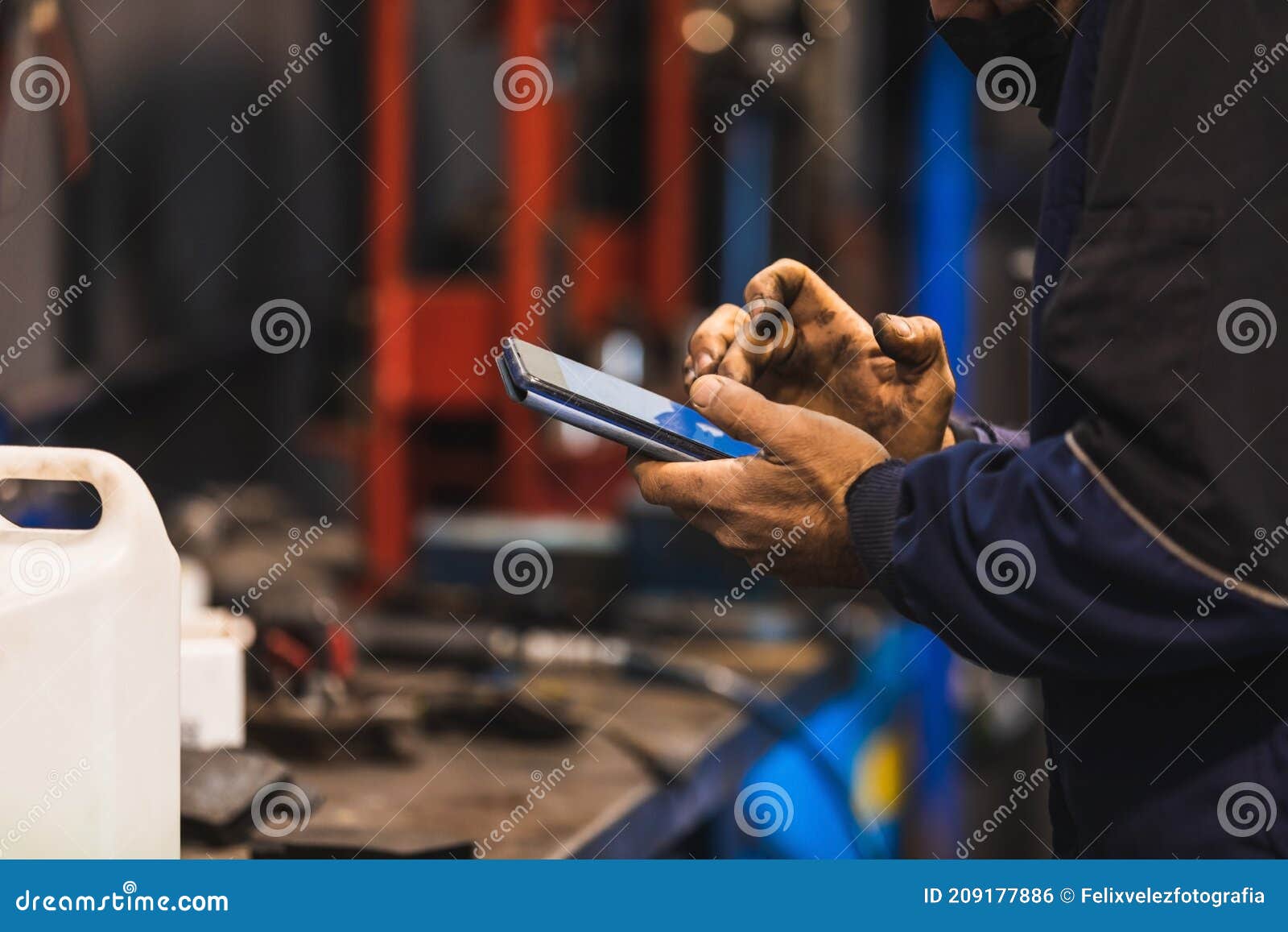 Mechanic Using Cell Phone in the Workshop. Hands Full of Grease Stock ...