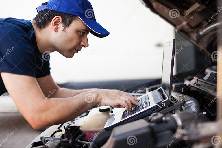 Mechanic Using a Laptop Computer To Check a Car Engine Stock Photo ...