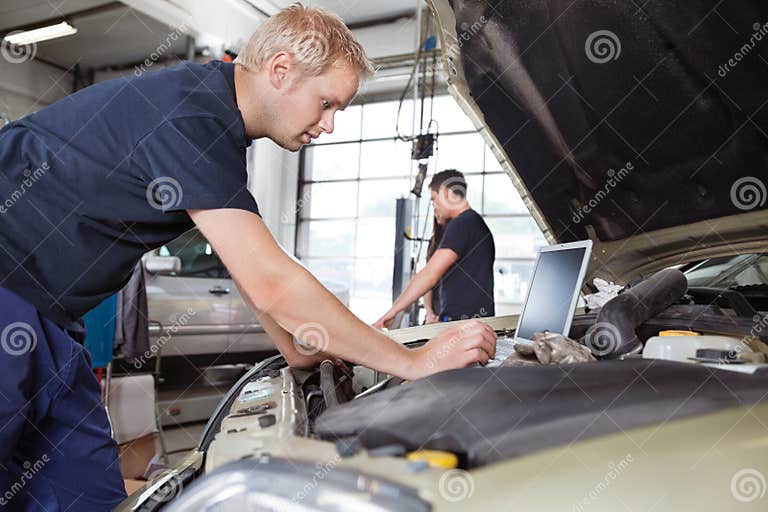 Mechanic Using Laptop while Working on Car Stock Photo - Image of ...