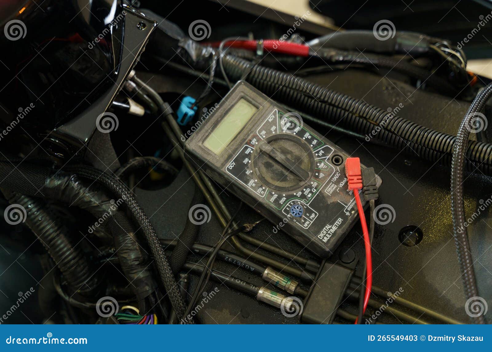 A Mechanic Using a Multimeter Checks the Voltage Level on a Motorcycle ...
