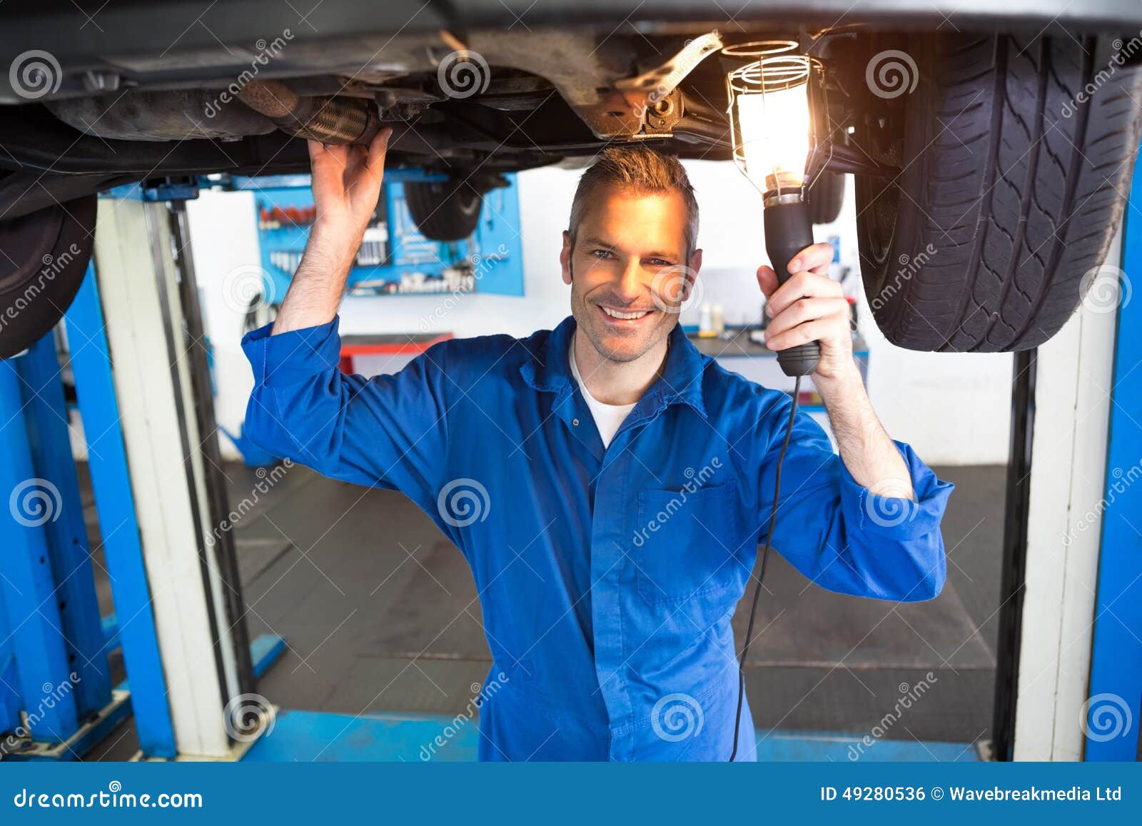 Mechanic Using Torch To Look Under Car Stock Photo - Image of worker ...