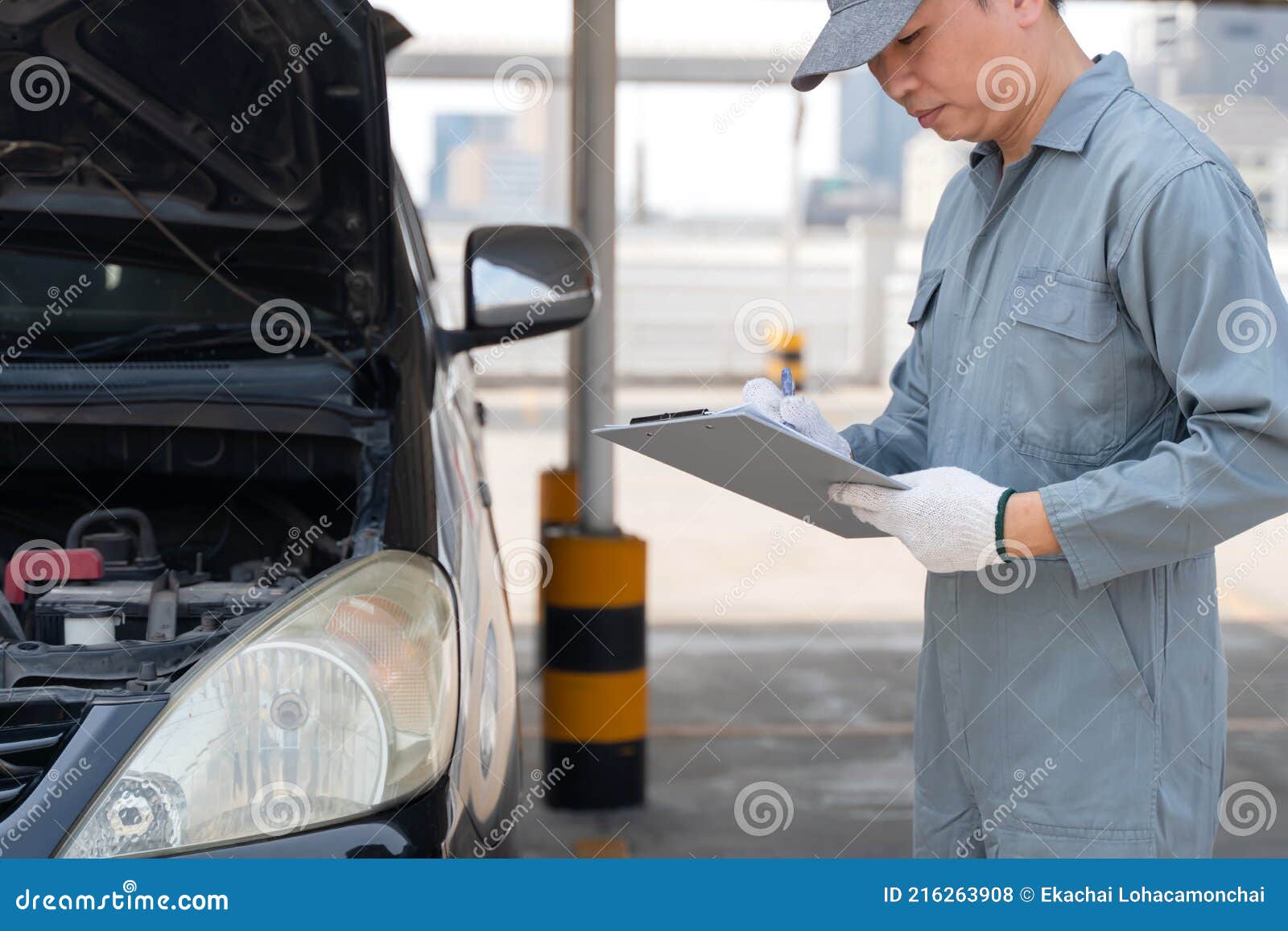 A Mechanic at Work in Garage, Mechanic Checking on a Car Engine and ...