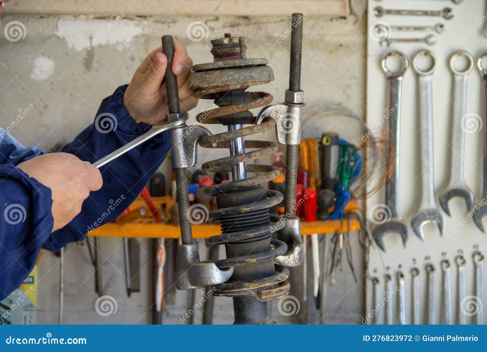 Mechanic at Work in His Workshop Disassembling Car Shock Absorbers ...