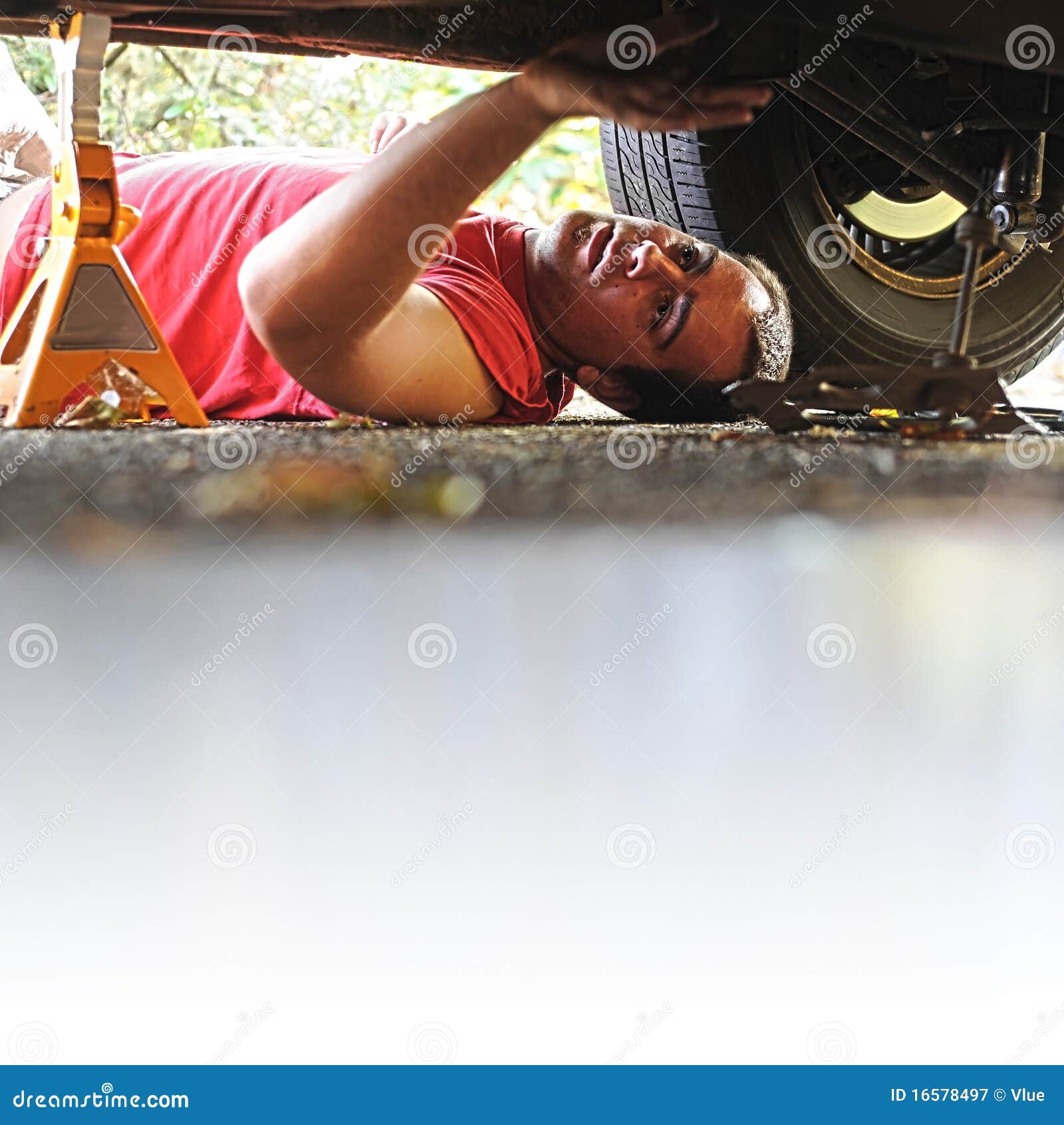 Mechanic working on a car stock image. Image of laying - 16578497