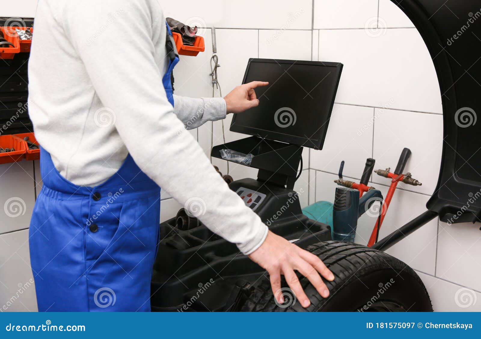 Mechanic Working with Wheel Balancing Machine at Tire Service Stock ...
