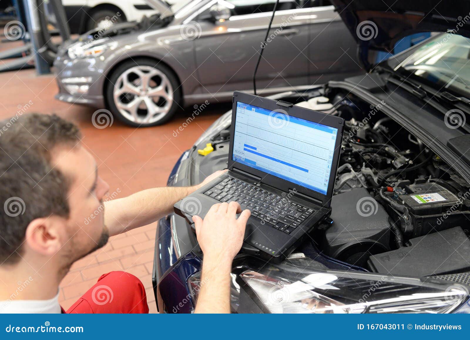 Mechanic in a Workshop Checks and Checks the Electronics of the Car ...