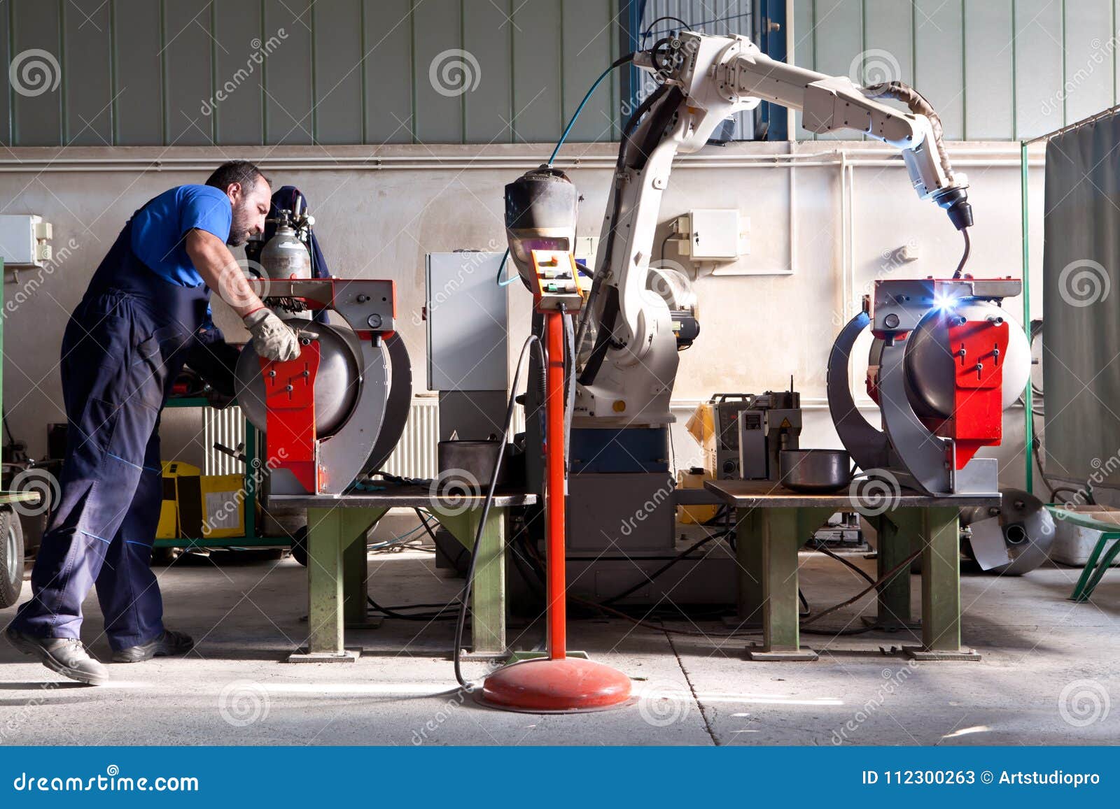 Man and Robotic Machine Work Together Inside Industrial Building. Stock ...