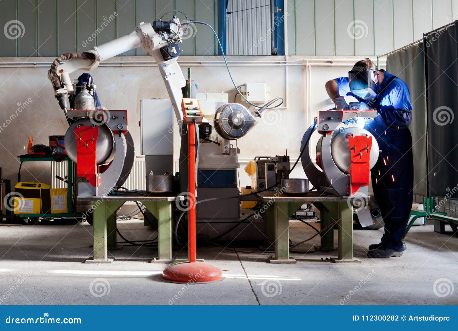 Man and Robotic Machine Work Together Inside Industrial Building. Stock ...