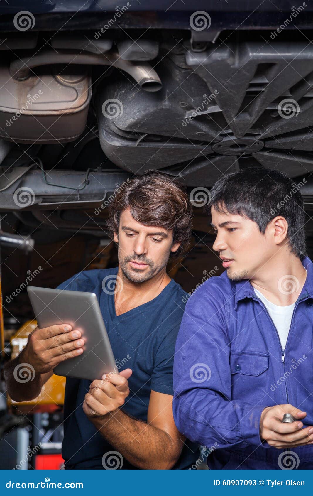 Mechanics Using Digital Tablet Under Lifted Car Stock Image - Image of ...