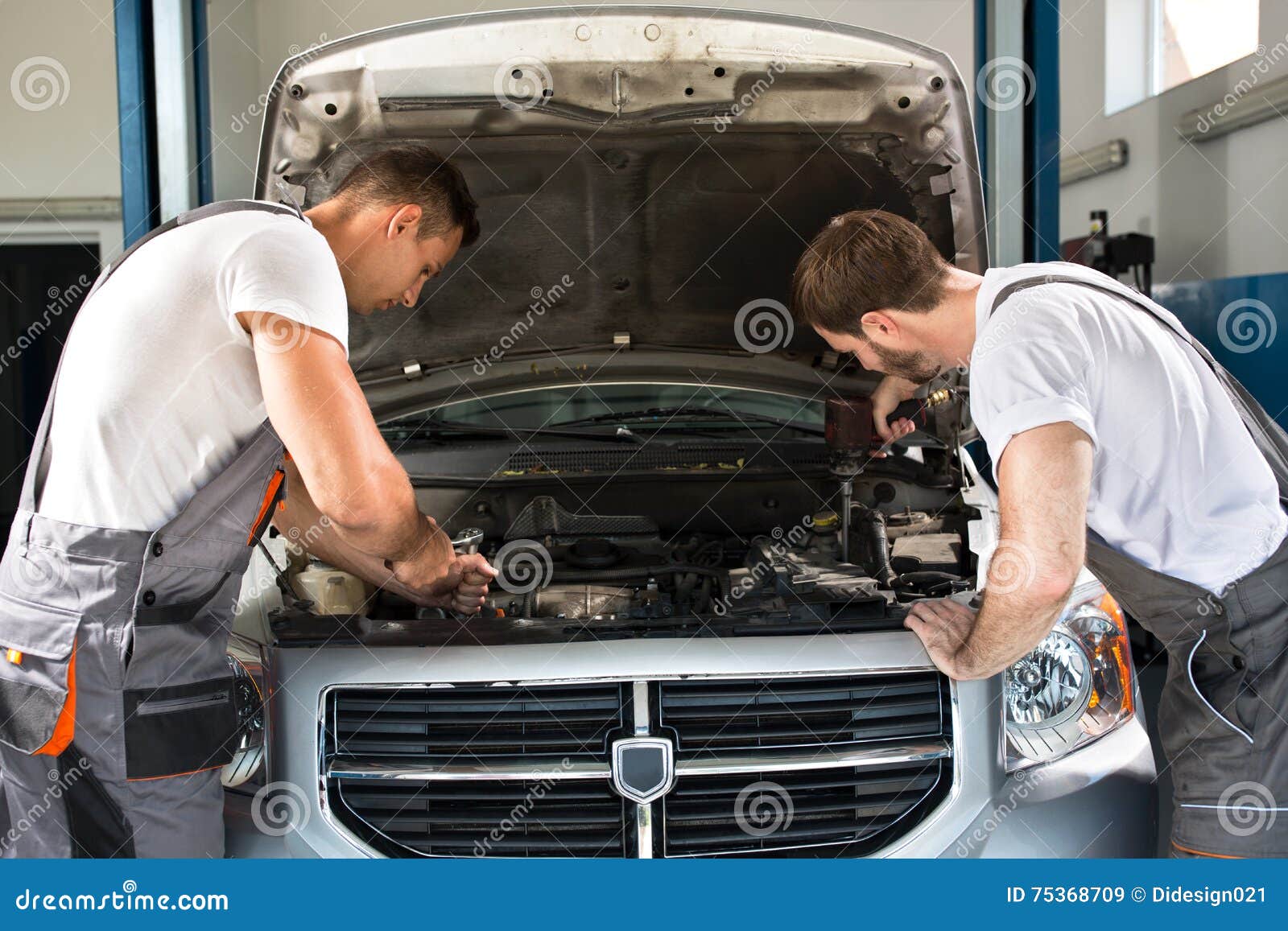 Mechanics working together stock image. Image of auto - 75368709