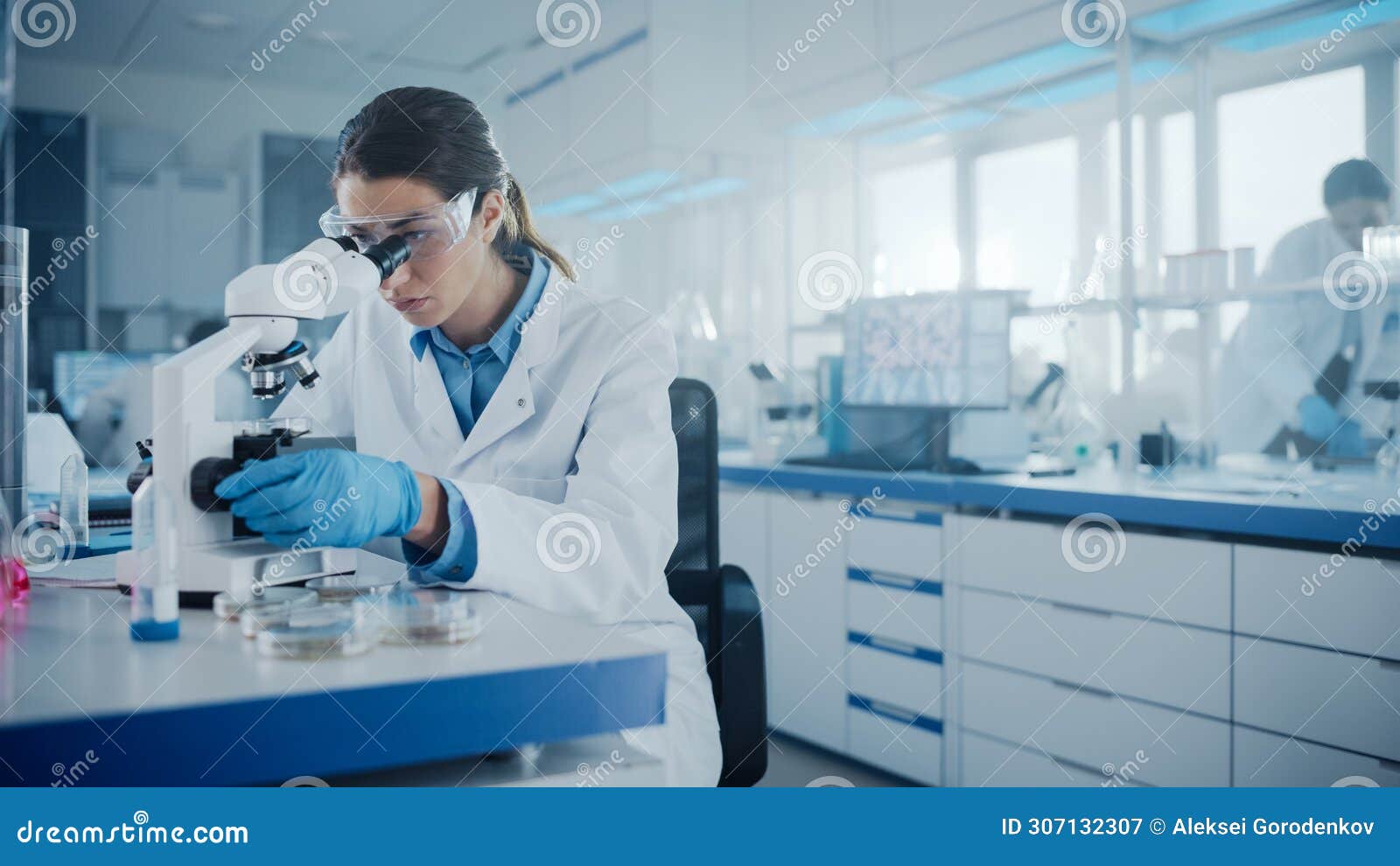 Medical Development Laboratory: Female Scientist Looking Under ...