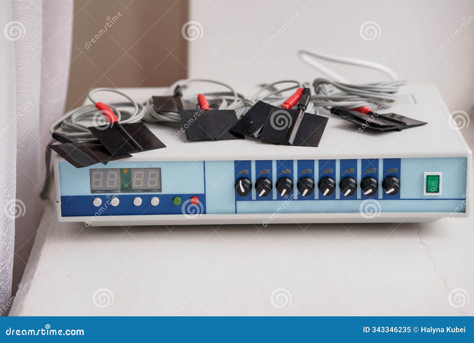 Medical Electrotherapy Device with Electrode Leads on a White Surface ...