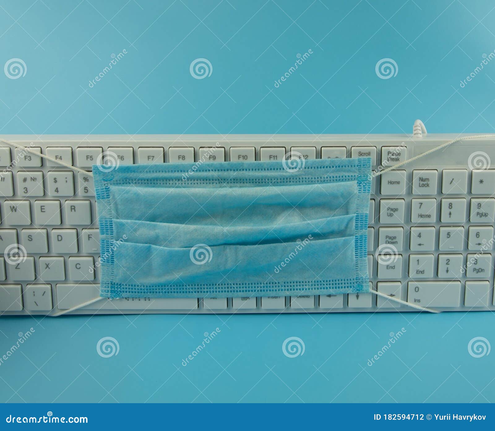 Medical Mask on a White Computer Keyboard, Remote Work Concept ...