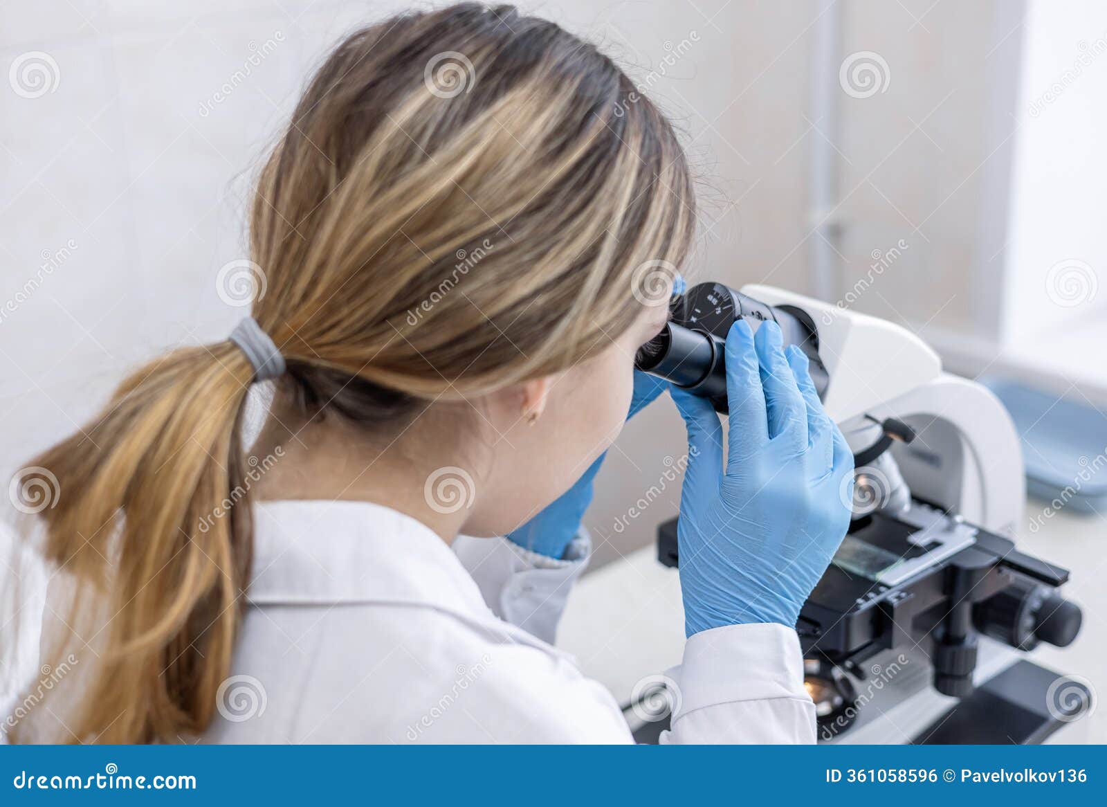Medical Science Laboratory: Female Biochemist Looks Under Microscope ...