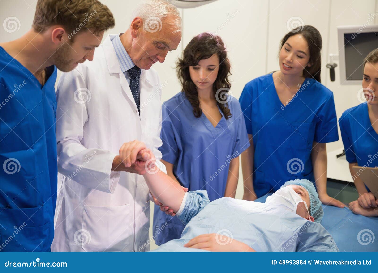 Medical Students and Professor Checking Pulse of Student Stock Photo ...