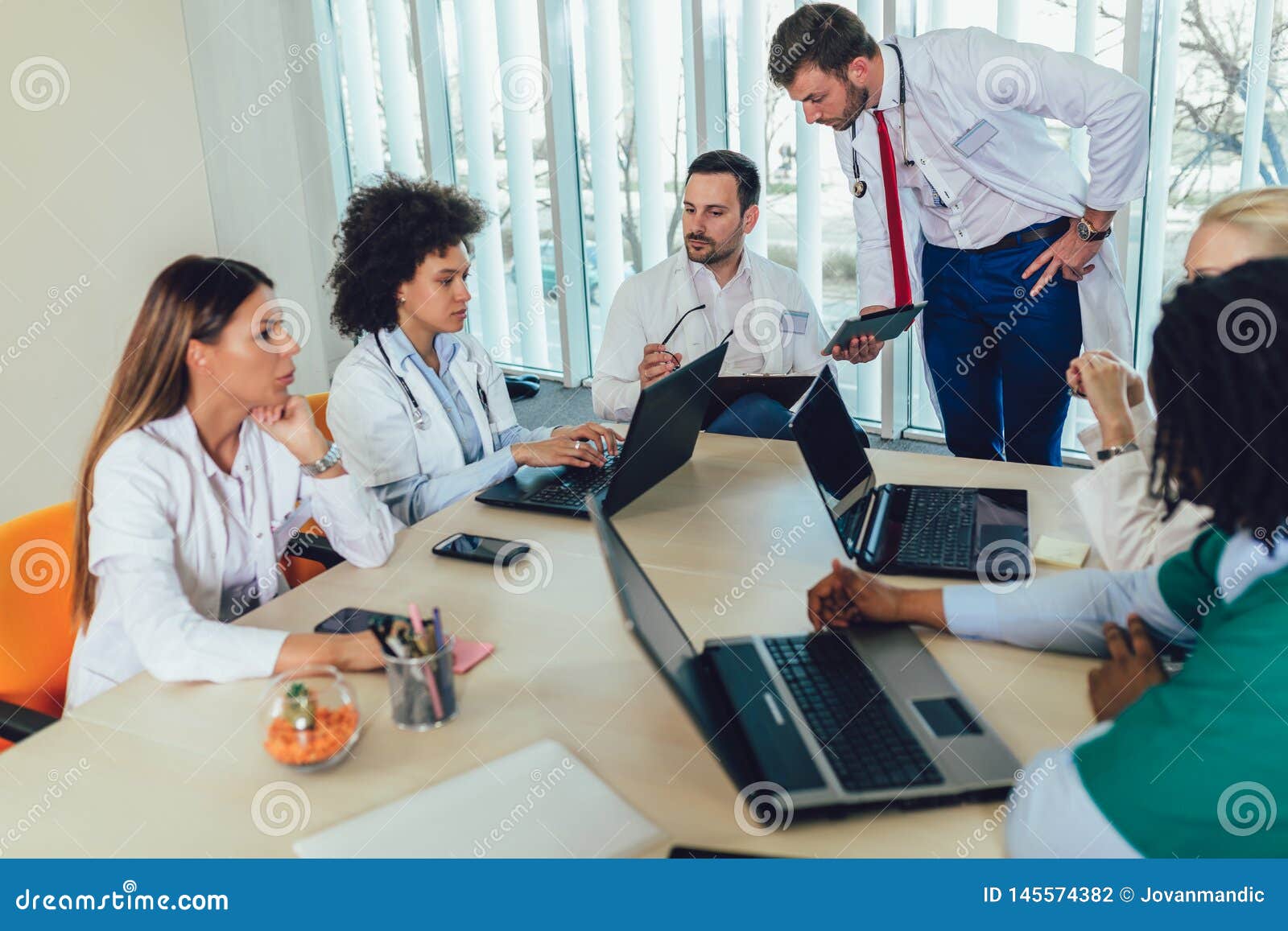 Medical Team Sitting and Discussing at the Table Stock Photo - Image of ...