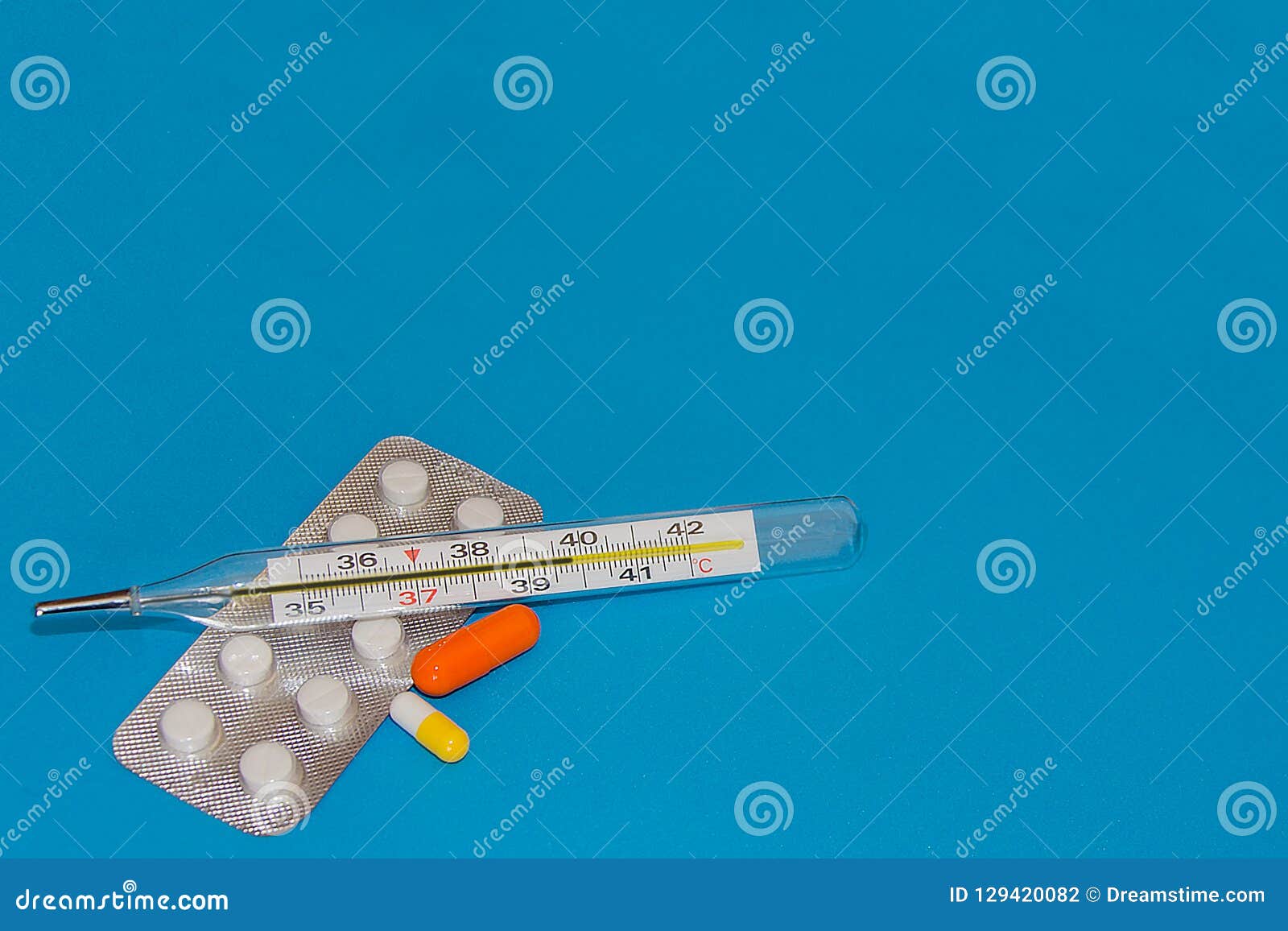 Medical Thermometer with Pills on on a Blue Background Stock Photo ...