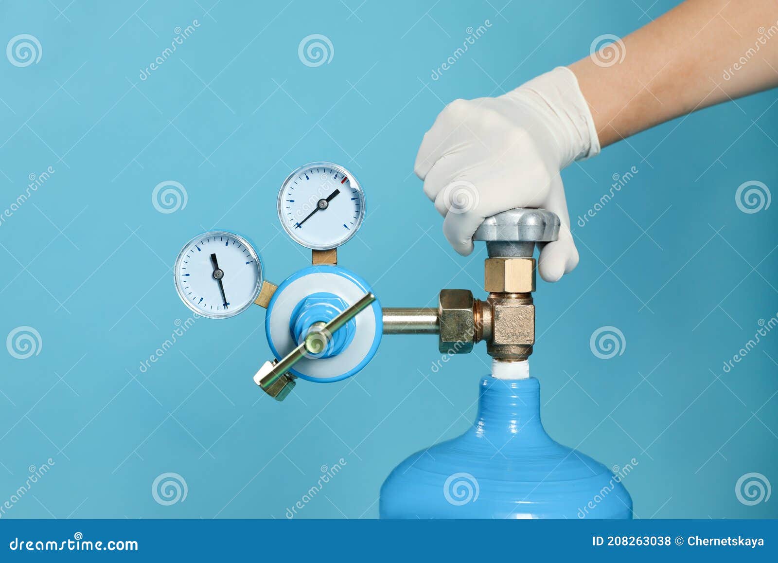 Medical Worker Checking Oxygen Tank on Light Blue Background, Closeup ...