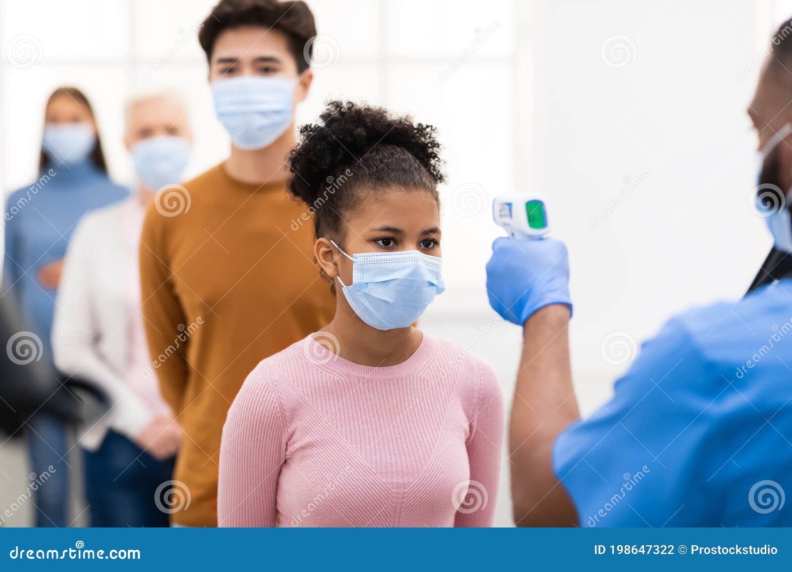Medical Worker Doing Temperature Screening for People in Queue Indoors ... Medical Worker Doing Temperature Screening for People in Queue Indoors ...