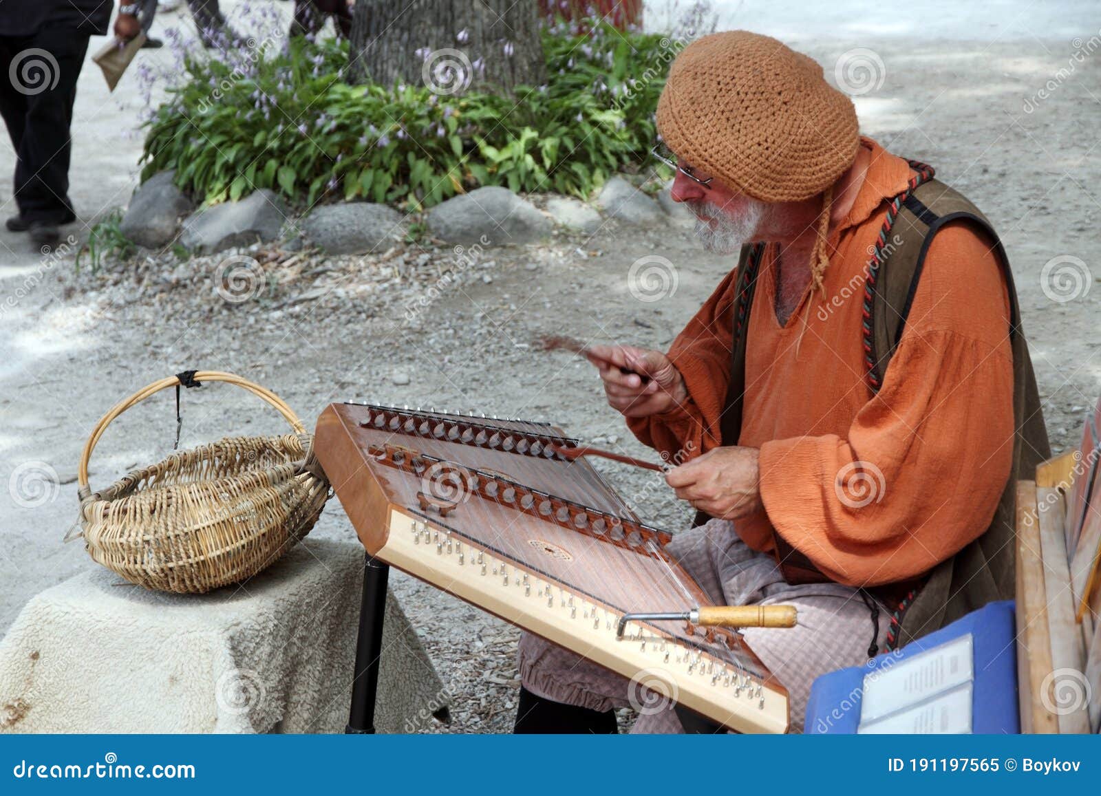 Medieval Dressed Musician Performs on a String Percussion Instrument ...