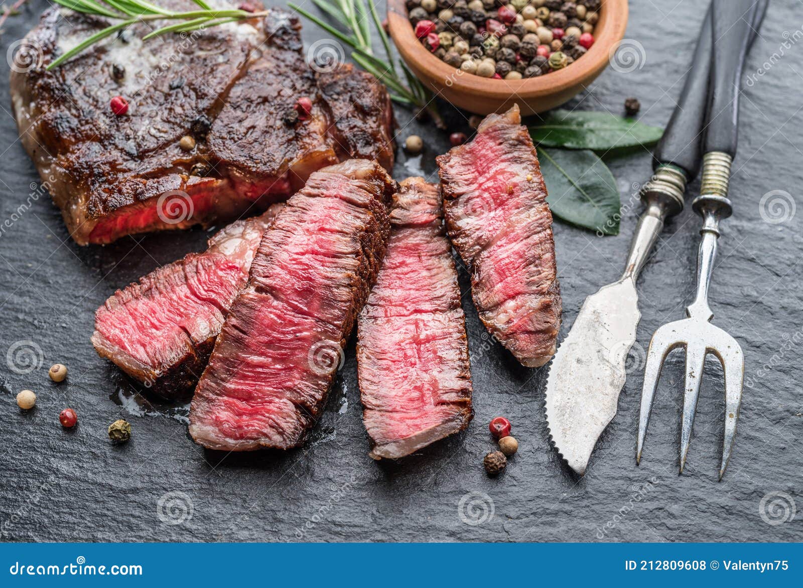 Medium Rare Ribeye Steak with Herbs on Graphite Board Stock Photo ...