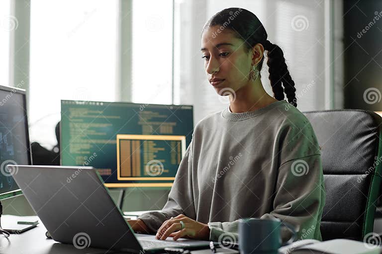 Middle Eastern Female Programmer Using Laptop Sitting at Workstation in ...