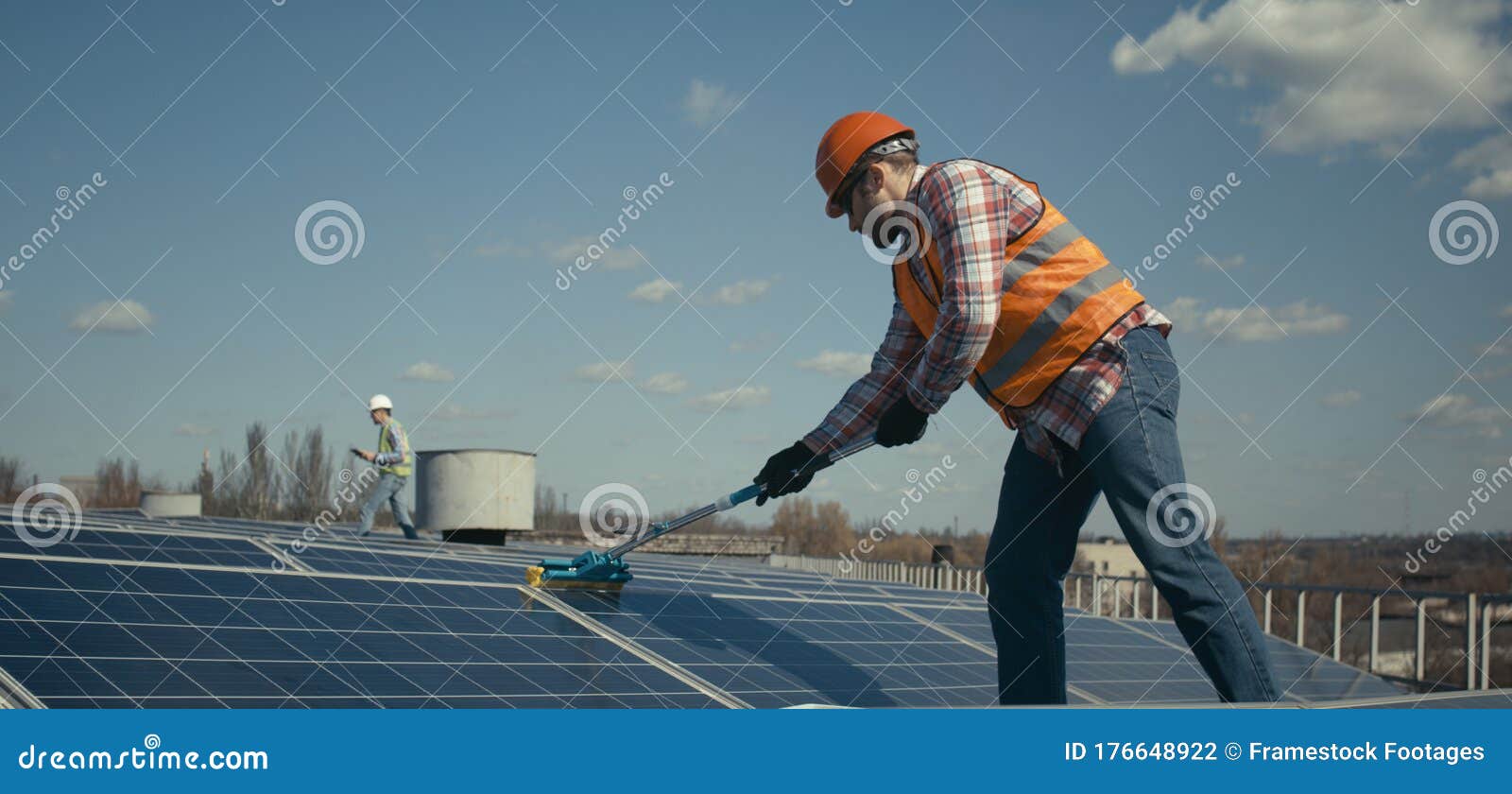Technician Cleaning Solar Panels on Flat Roof Stock Photo - Image of ...
