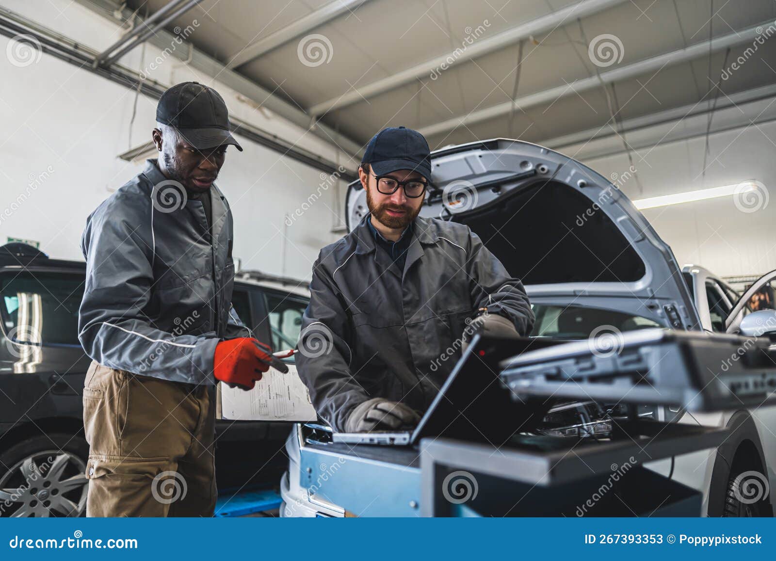 Medium Shot of Two Mechanics Doing Computer Diagnostics of a Car and ...