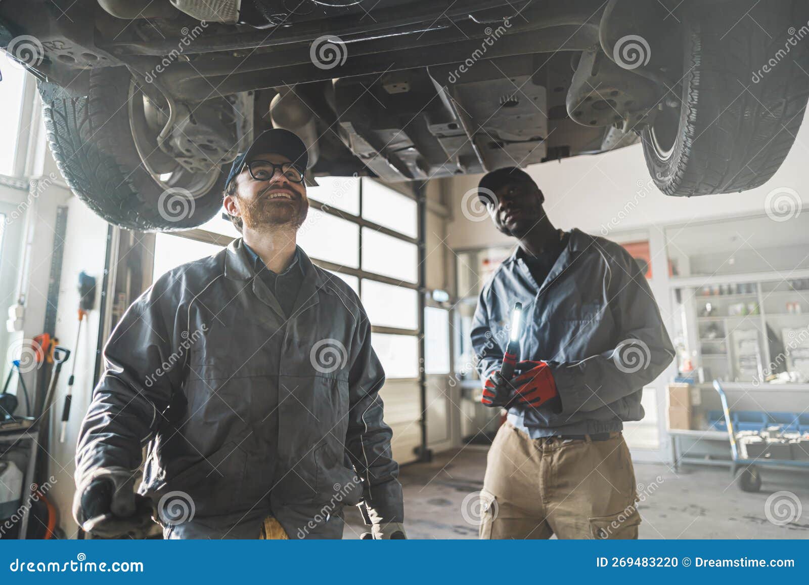 Medium Shot of Two Mechanics Inspecting Car S Underside Stock Photo ...