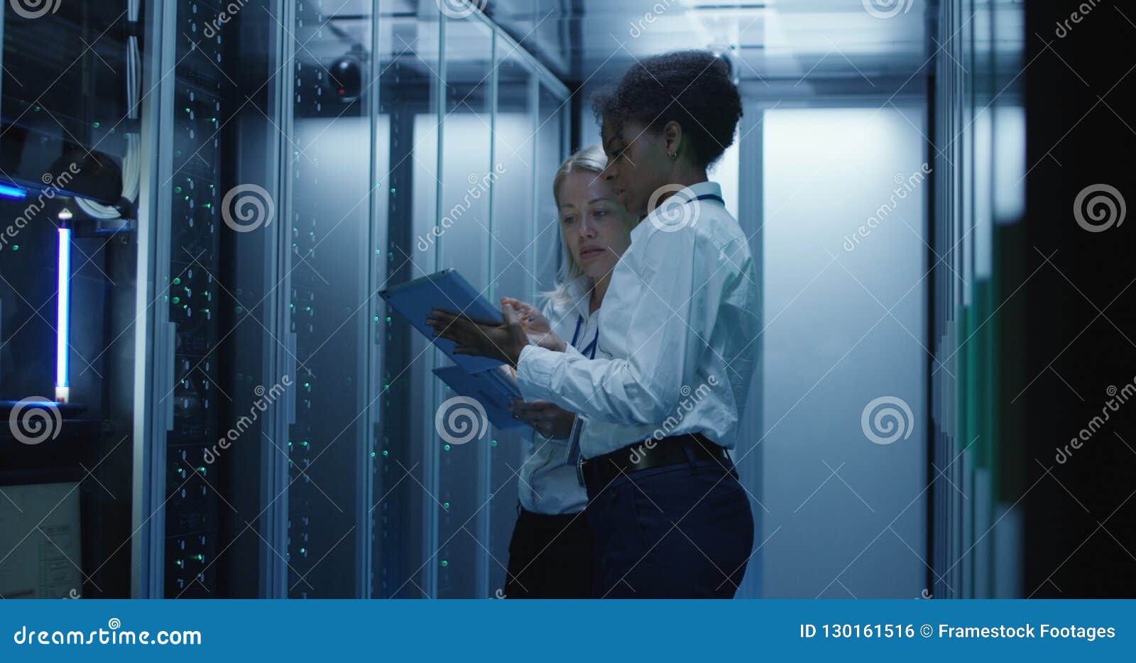 Two Women are Working in a Data Center with Rows of Server Racks Stock ...