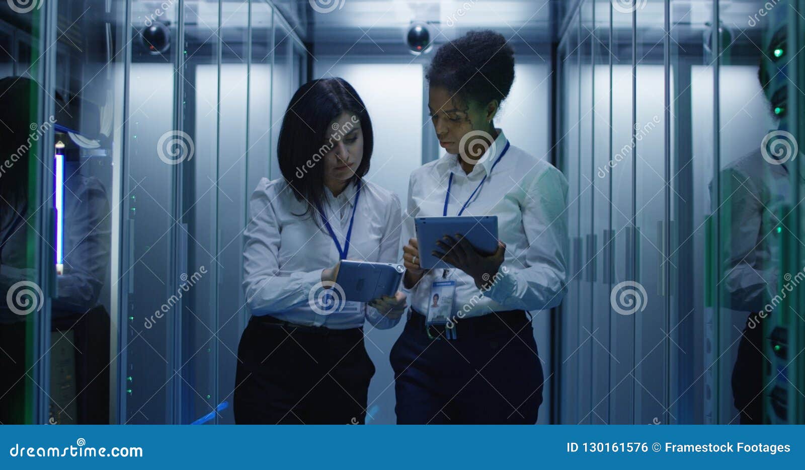 Two Women are Working in a Data Center with Rows of Server Racks Stock ...