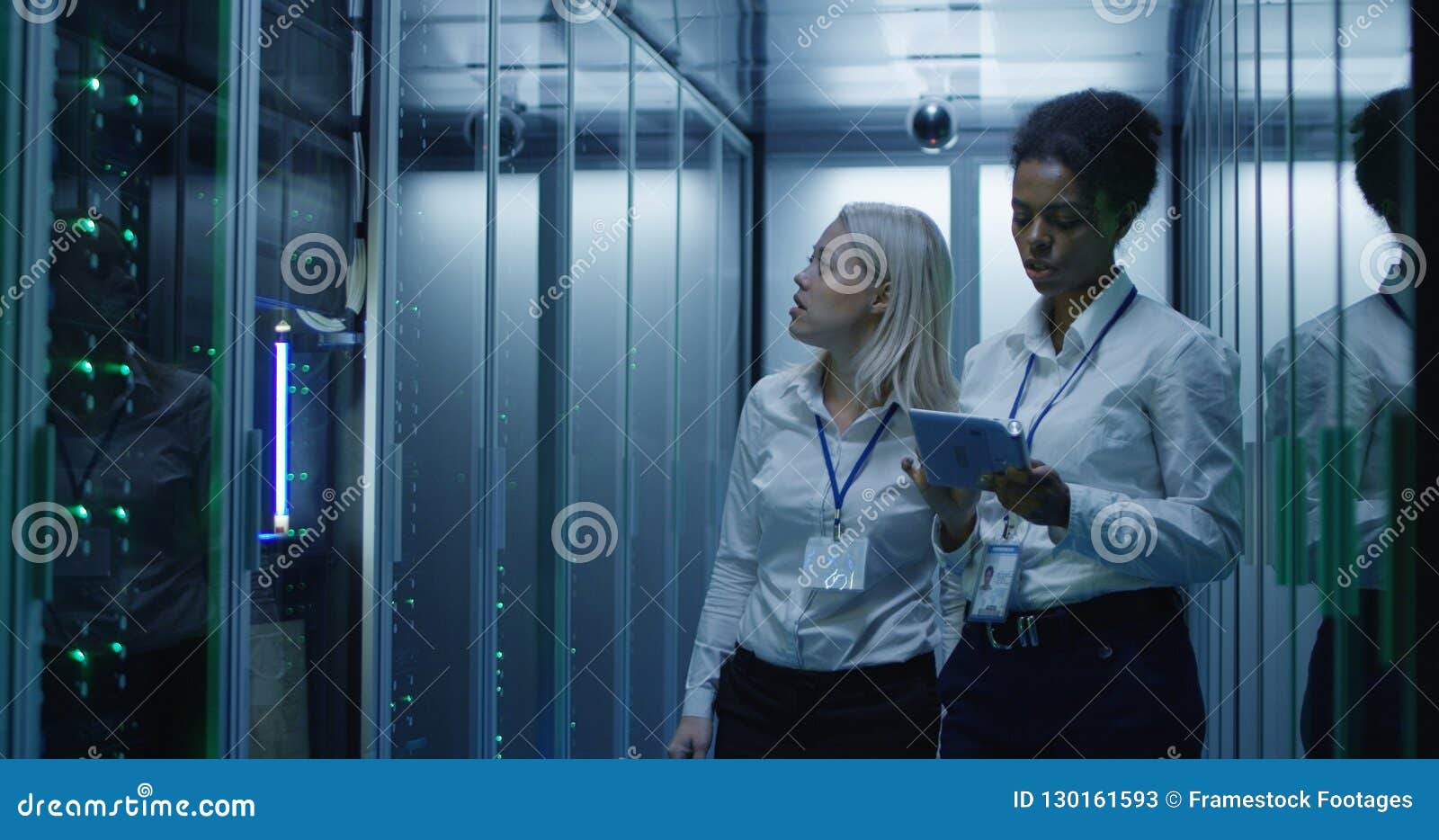 Two Women are Working in a Data Center with Rows of Server Racks Stock ...