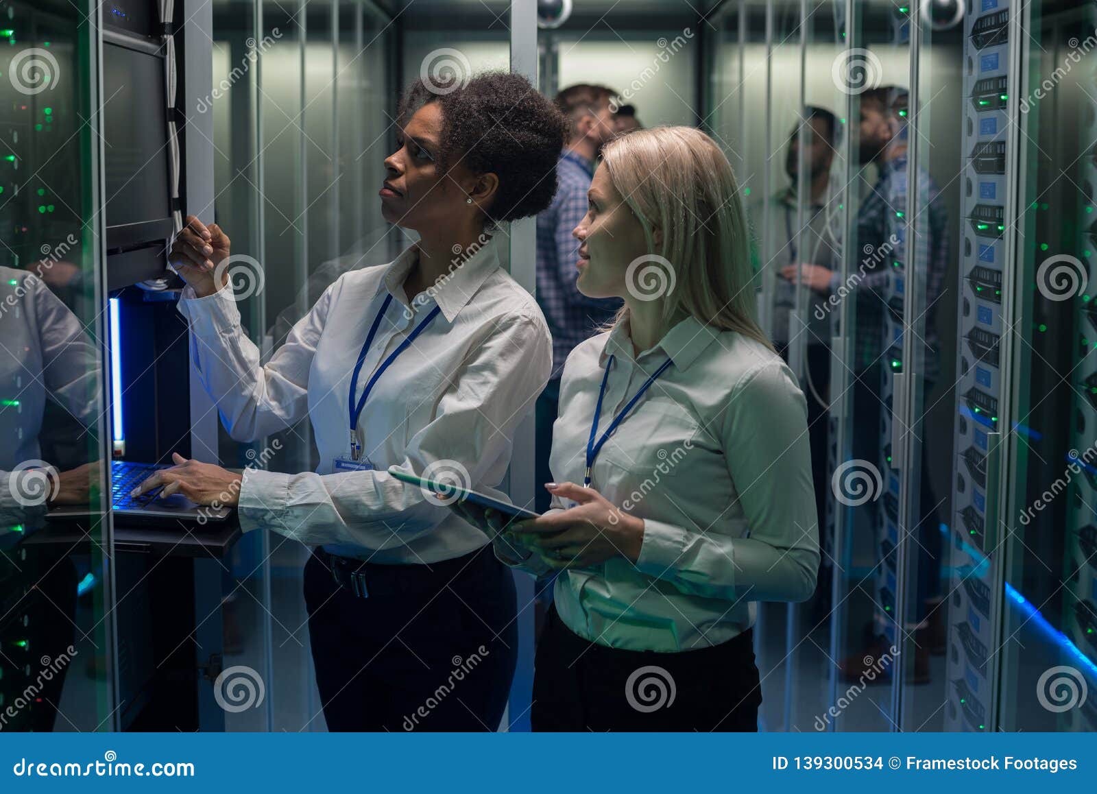 Two Women are Working in a Data Center with Rows of Server Racks Stock ...