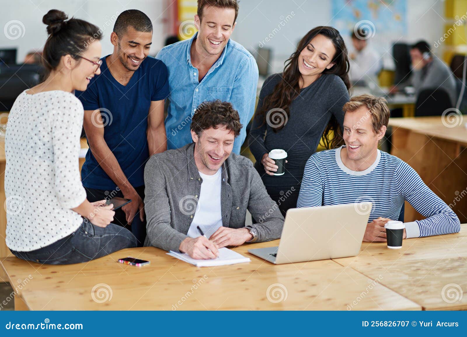 The Meeting of Creative Minds. a Group of Colleagues Using a Laptop Together in a Casual Work ...