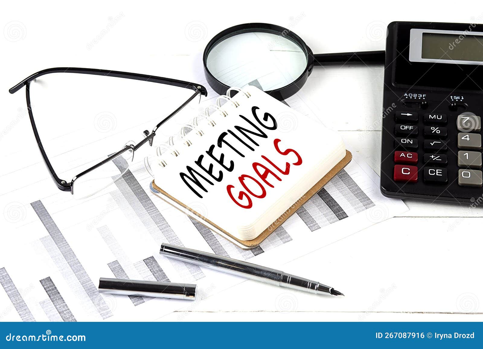 MEETING GOALS Text on Notebook with Calculator on Diagram Background ...