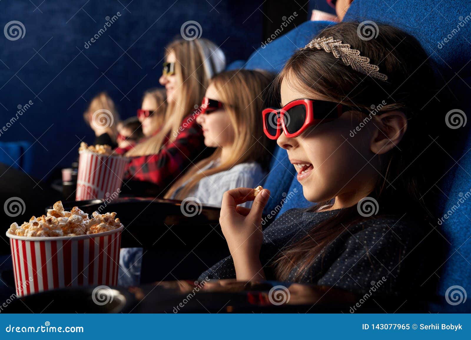 Meisje Die Popcorn Eten Lettend Op Beeldverhaal In Bioskoop Stock