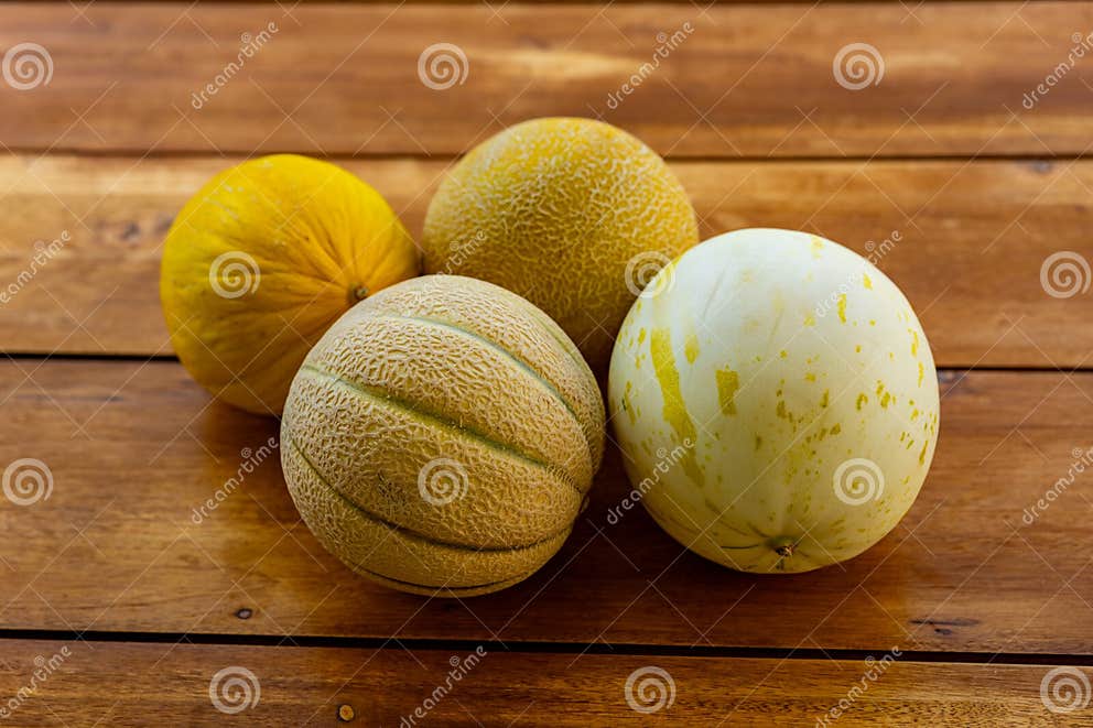 Melons of Four Different Varieties Lying on a Rustic Wooden Table Stock ...