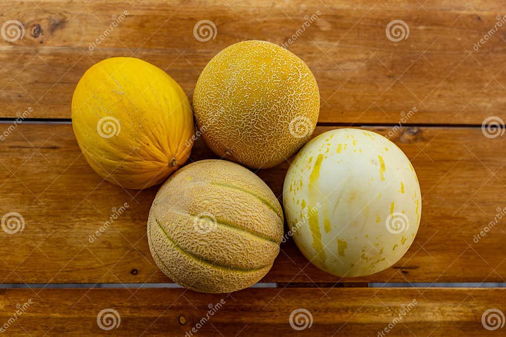 Melons of Four Different Varieties Lying on a Rustic Wooden Table Stock ...