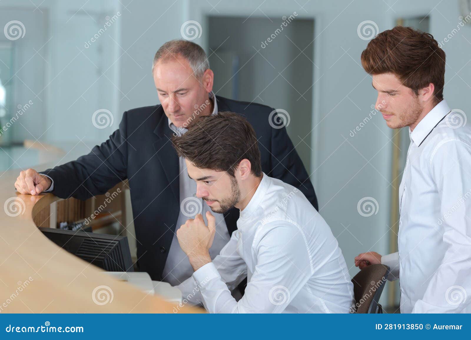 Men Behind Reception Desk Looking at Computer Stock Photo - Image of ...