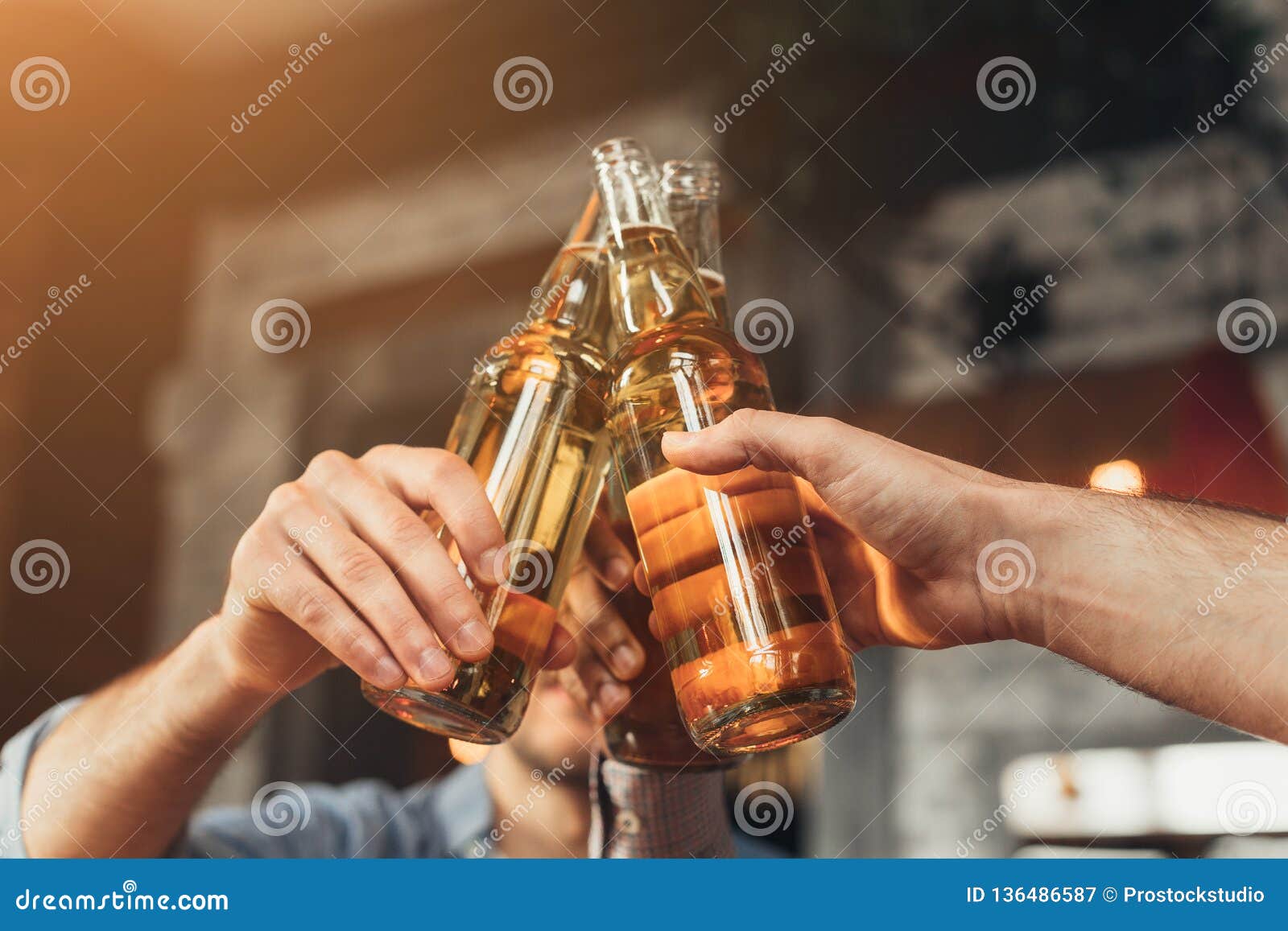 Men Clinking Bottles of Beer Together in Bar Stock Image - Image of ...